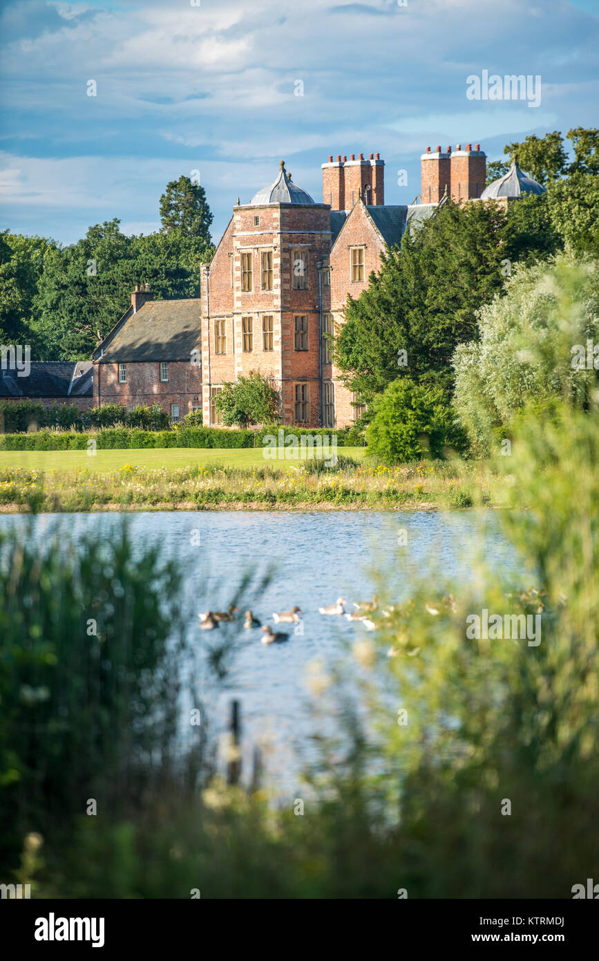 Warm sunlight beats down on historic Kiplin Hall overlooking lake ...