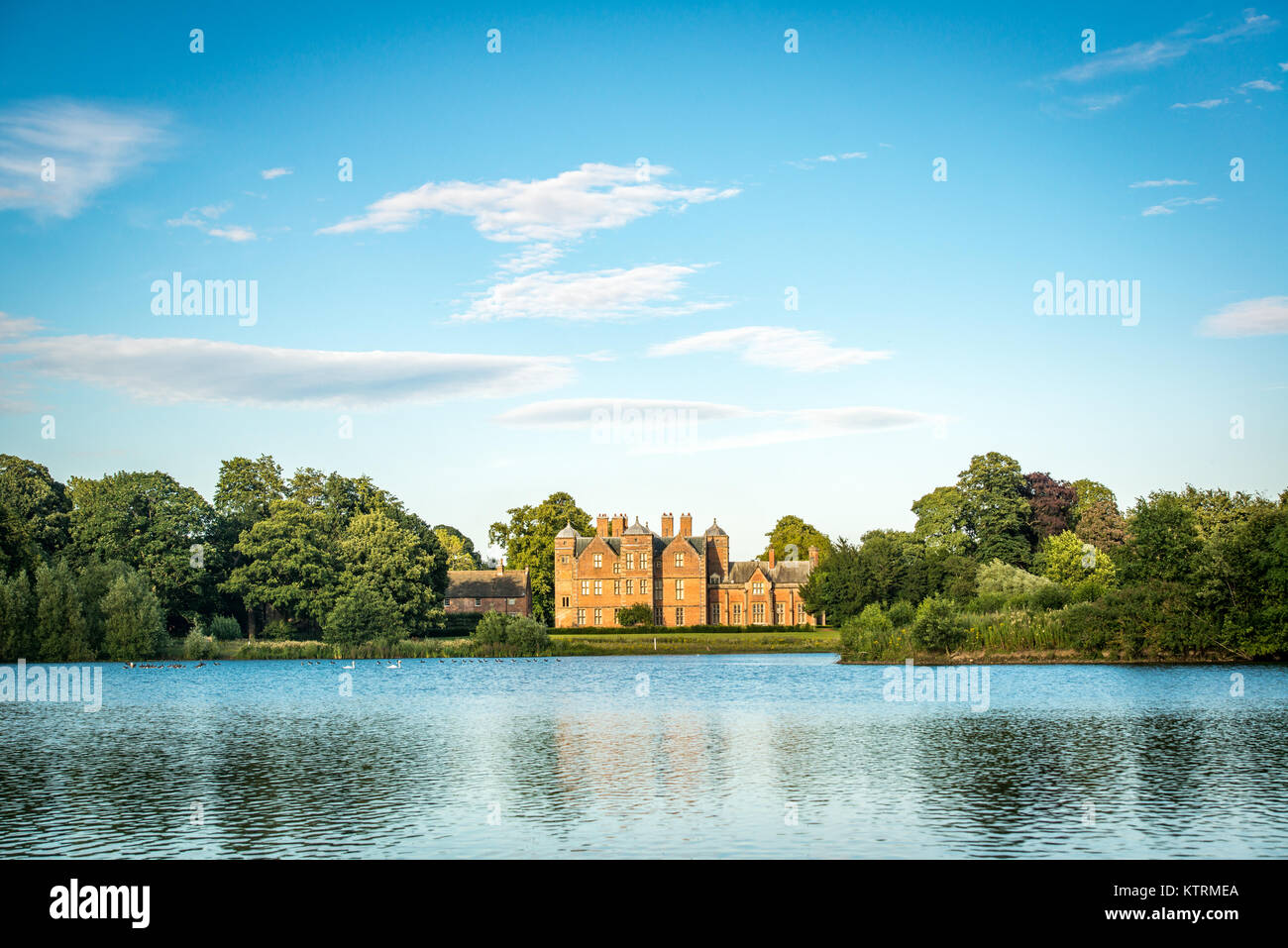Warm sunlight illuminates Kiplin Hall facing lake, Scorton, Richmond ...