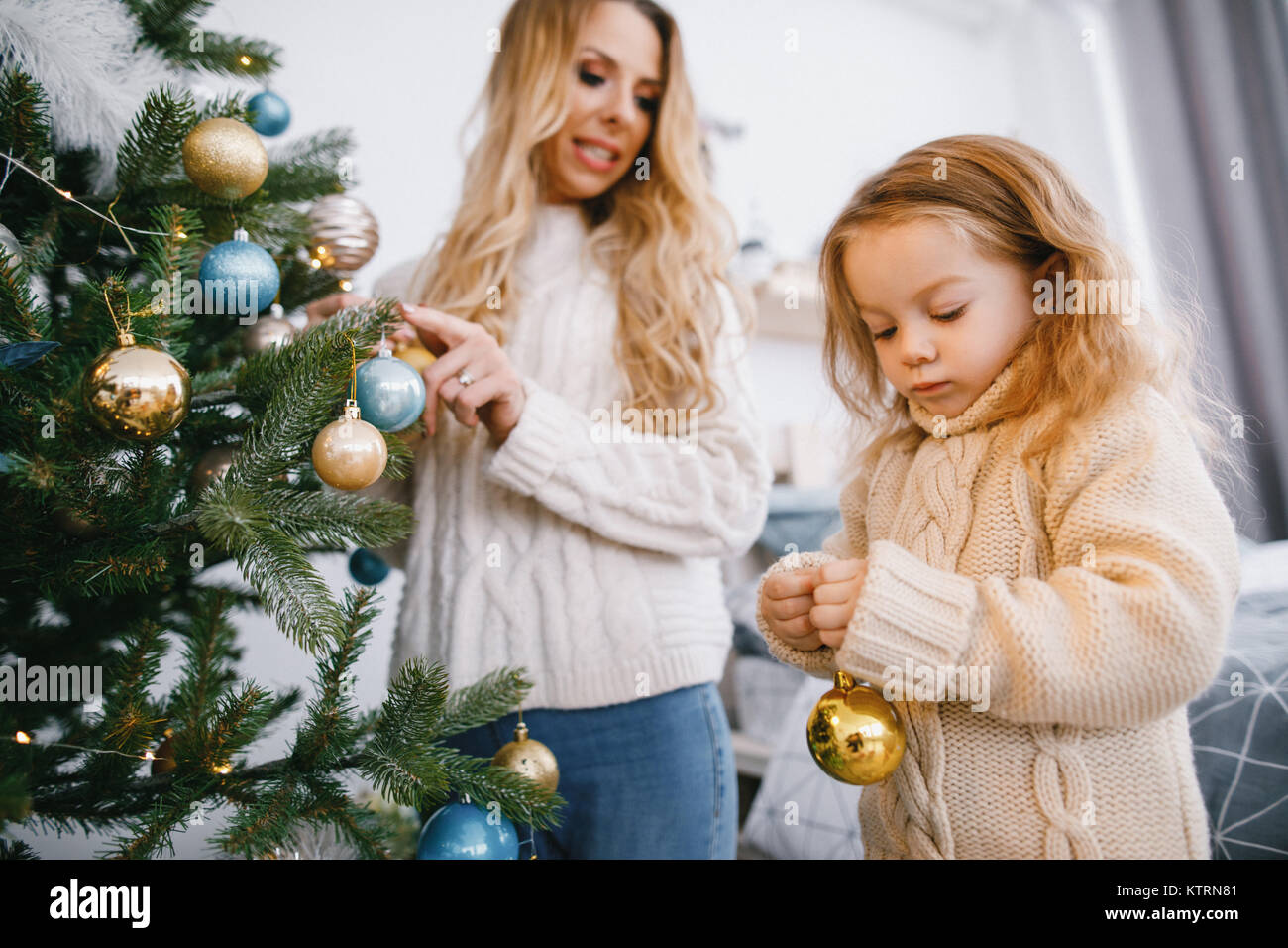 mother and daughter decorating the tree Stock Photo - Alamy
