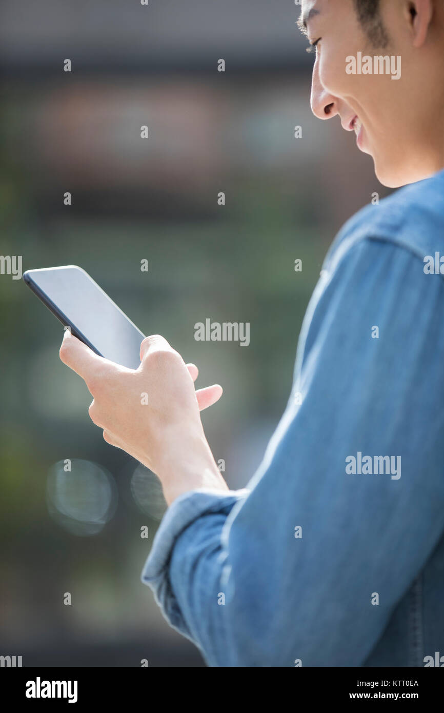 Young man using smart phone Stock Photo - Alamy