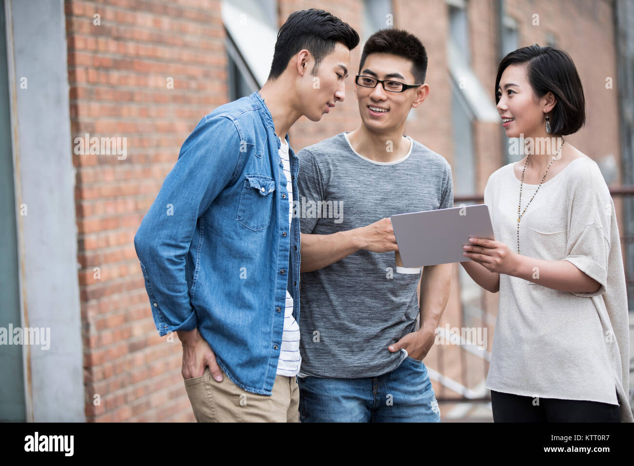 Confident designer team talking outdoors Stock Photo - Alamy