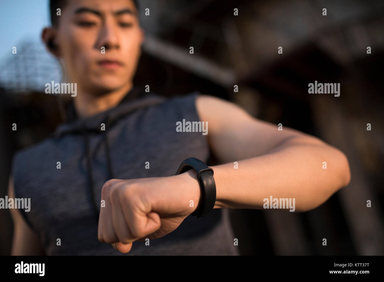 Young man checking smart watch after running Stock Photo - Alamy