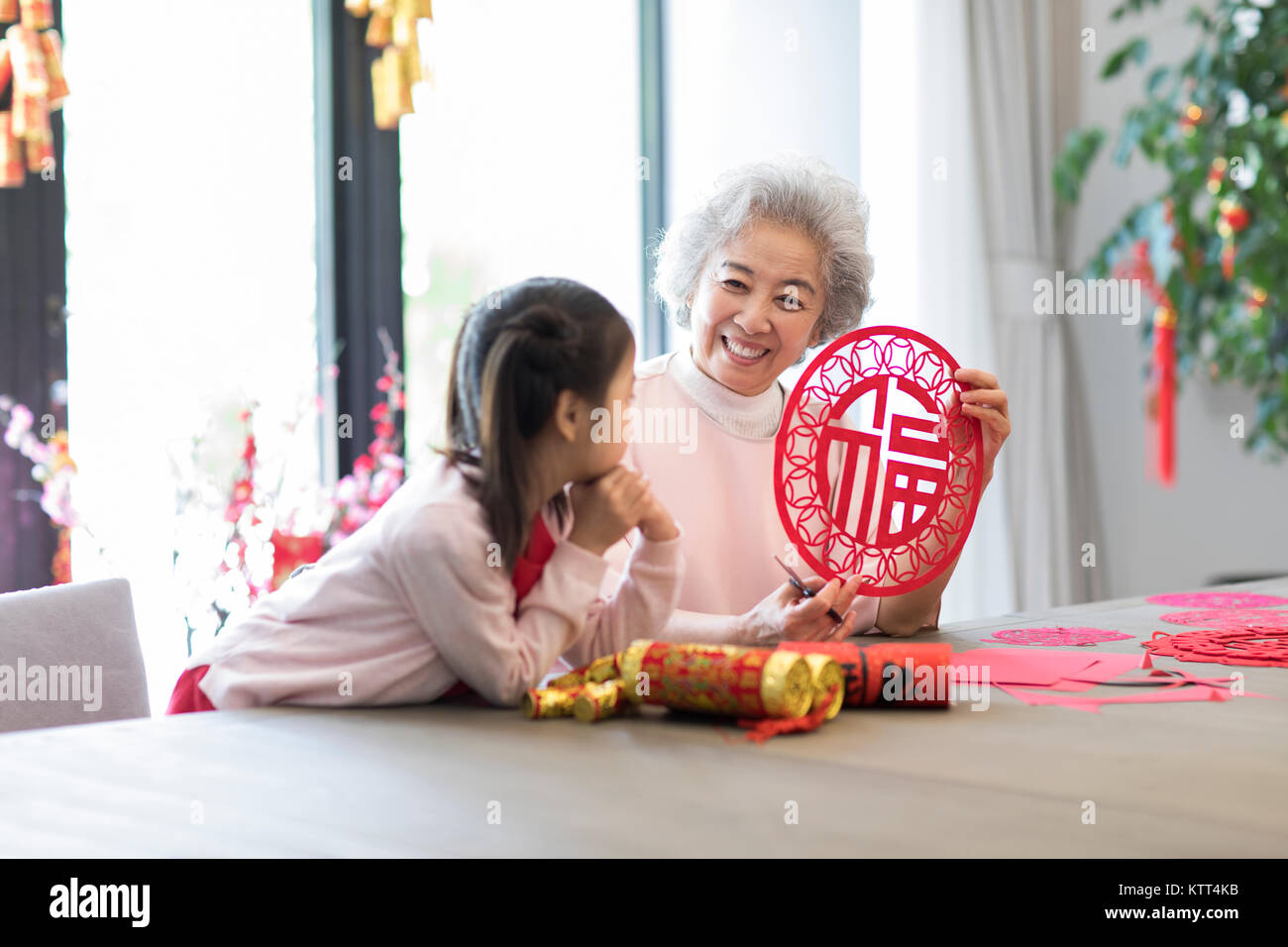 Granddaughter and grandmother with Chinese New Year paper-cut Stock ...
