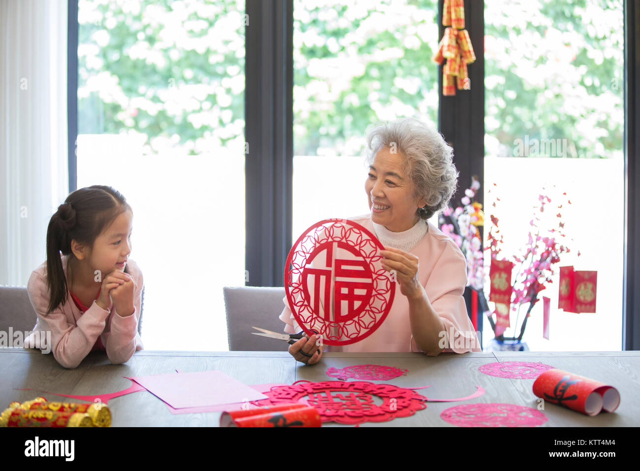 Granddaughter and grandmother with Chinese New Year paper-cut Stock ...