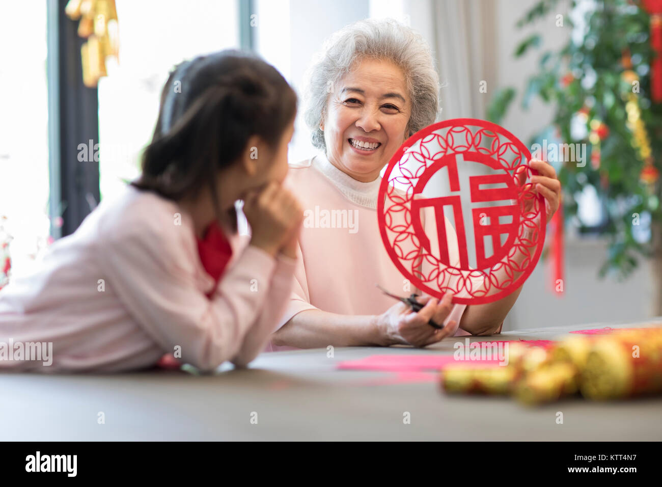 Granddaughter and grandmother with Chinese New Year paper-cut Stock ...