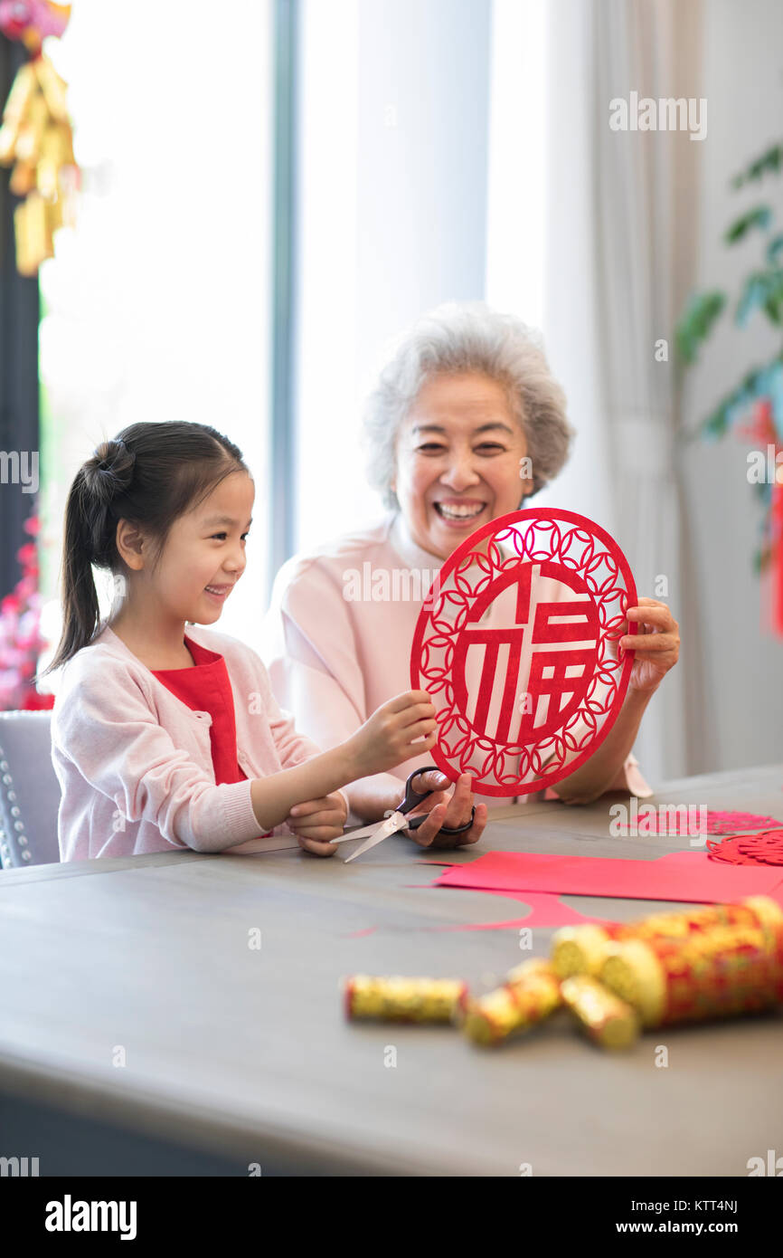Granddaughter and grandmother with Chinese New Year paper-cut Stock ...