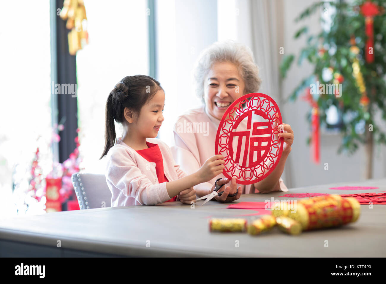 Granddaughter and grandmother with Chinese New Year paper-cut Stock ...