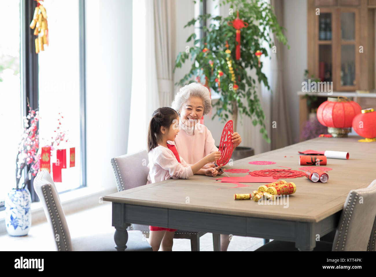 Granddaughter and grandmother with Chinese New Year paper-cut Stock ...