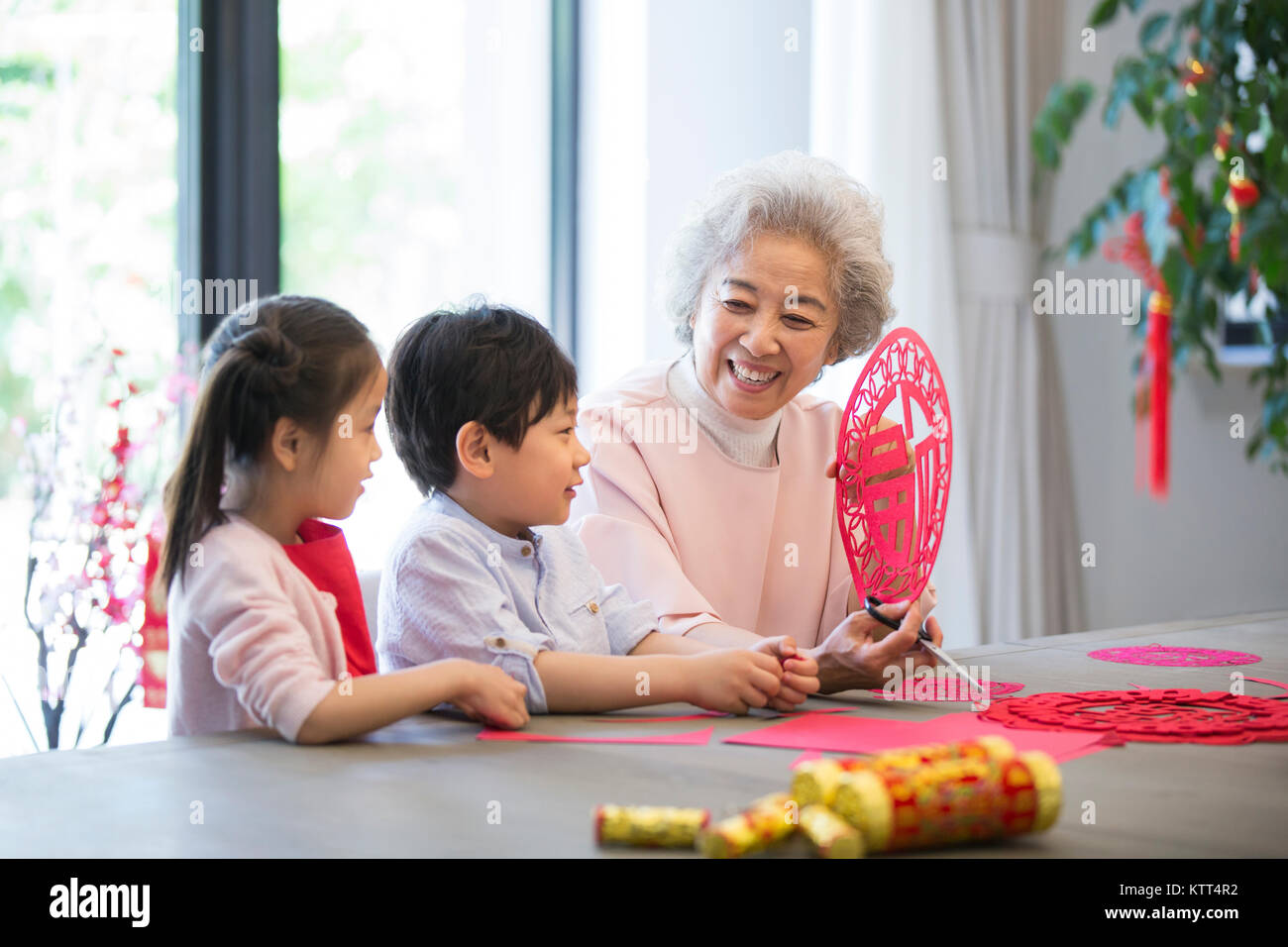 Grandchildren and grandmother with Chinese New Year paper-cut Stock ...