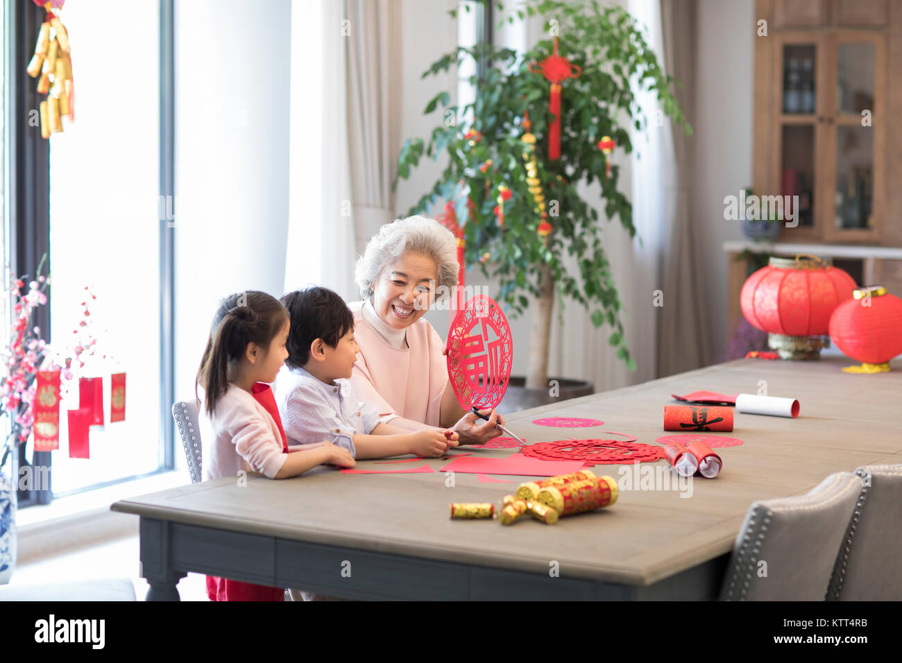 Grandchildren and grandmother with Chinese New Year paper-cut Stock ...