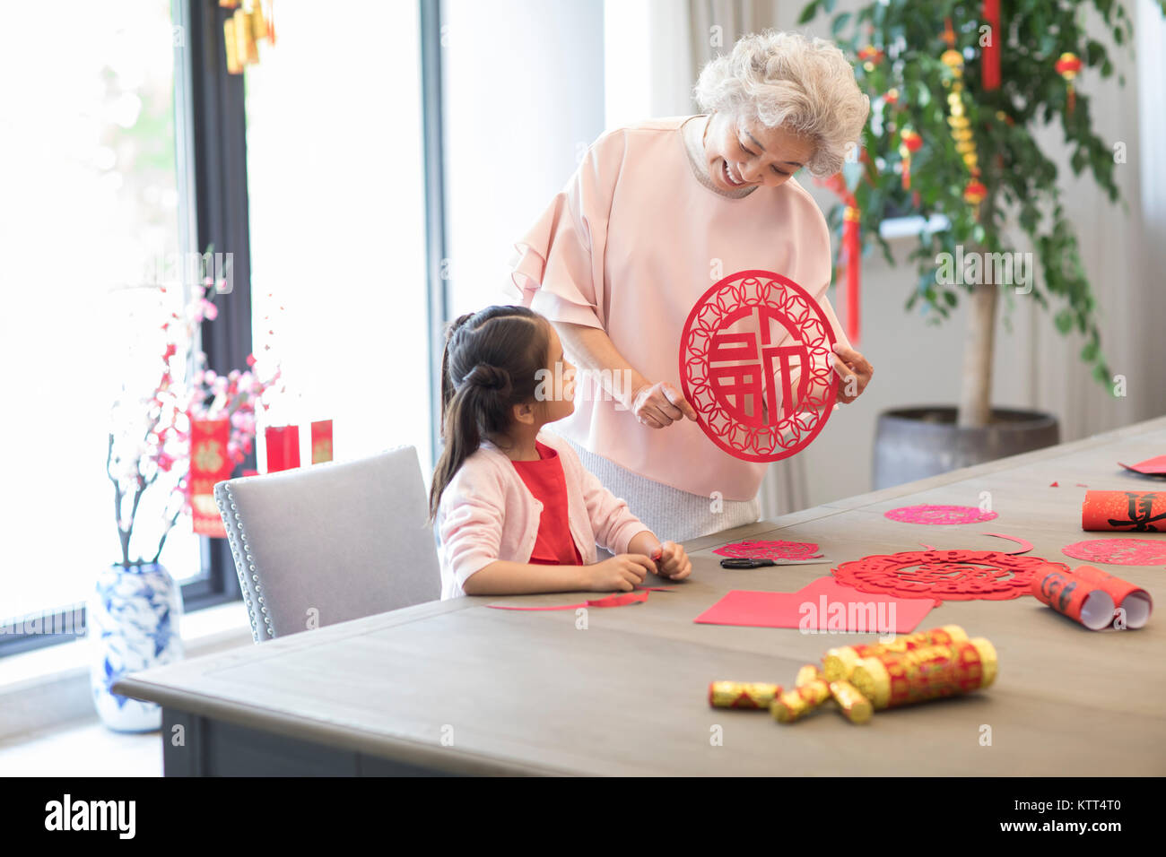 Granddaughter and grandmother with Chinese New Year paper-cut Stock ...