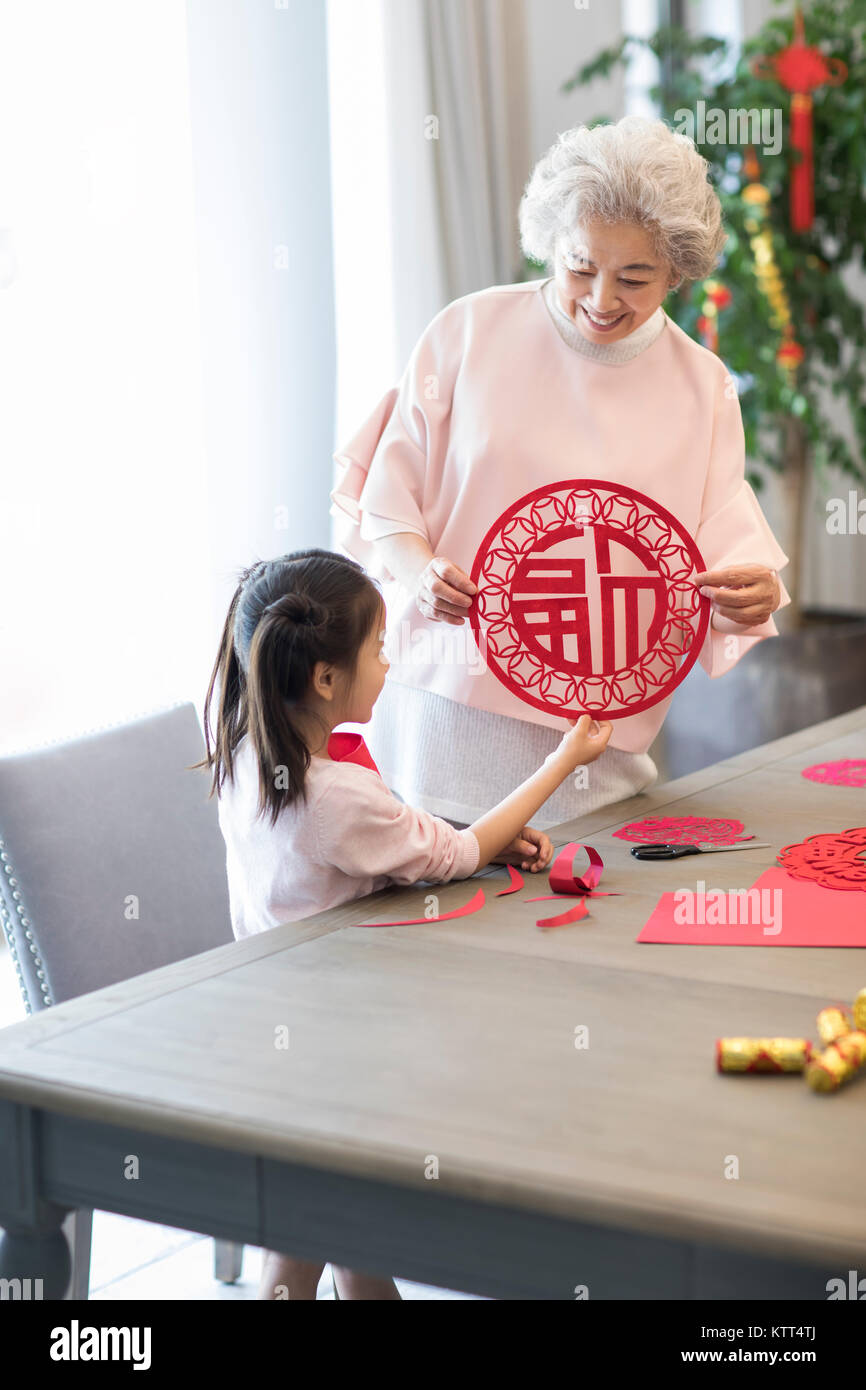 Granddaughter and grandmother with Chinese New Year paper-cut Stock ...