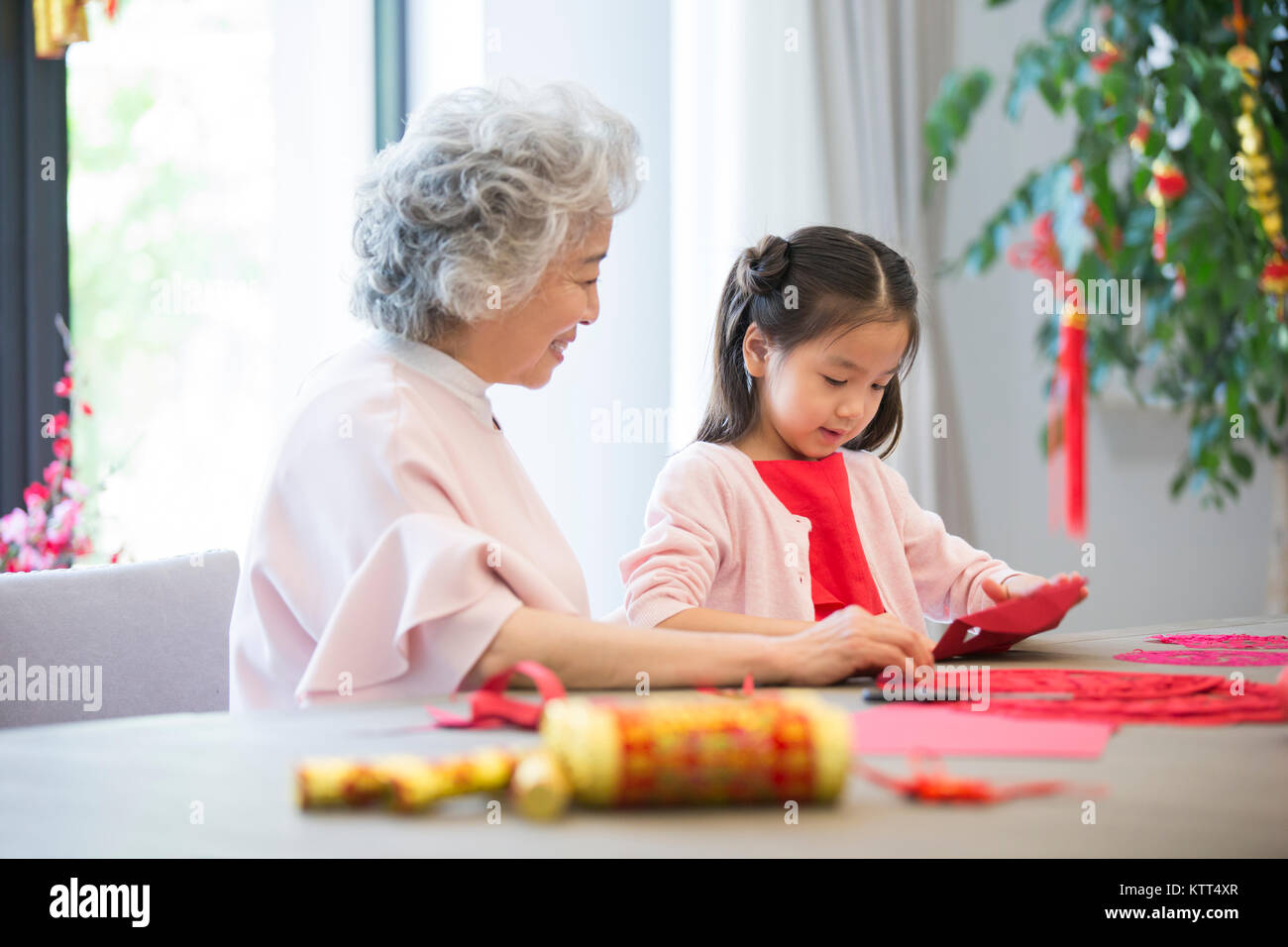 Granddaughter and grandmother with Chinese New Year paper-cut Stock ...