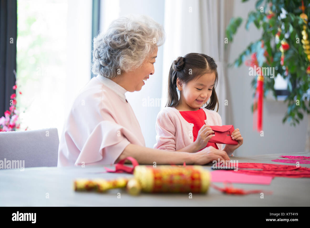 Granddaughter and grandmother with Chinese New Year paper-cut Stock ...