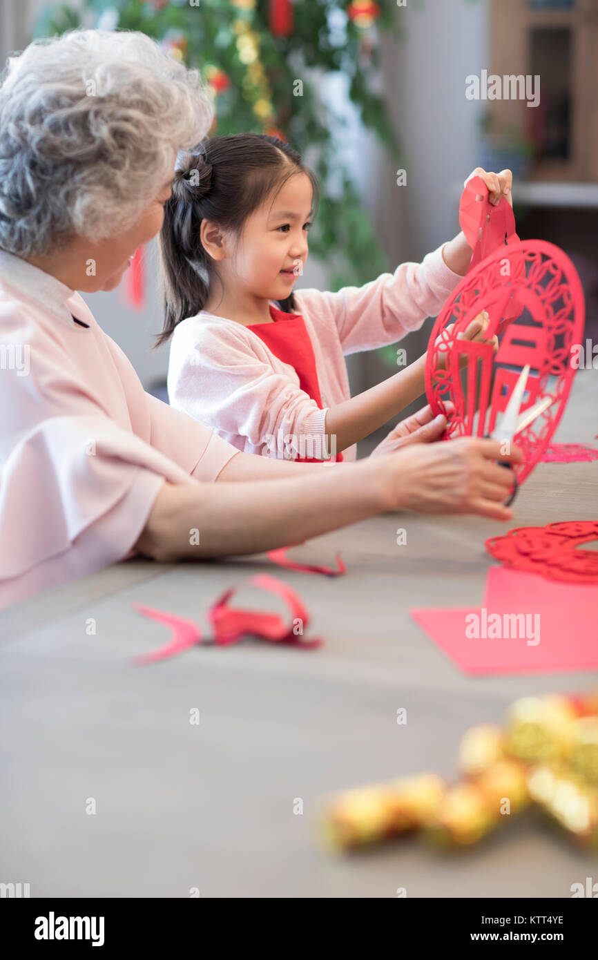 Granddaughter and grandmother with Chinese New Year paper-cut Stock ...