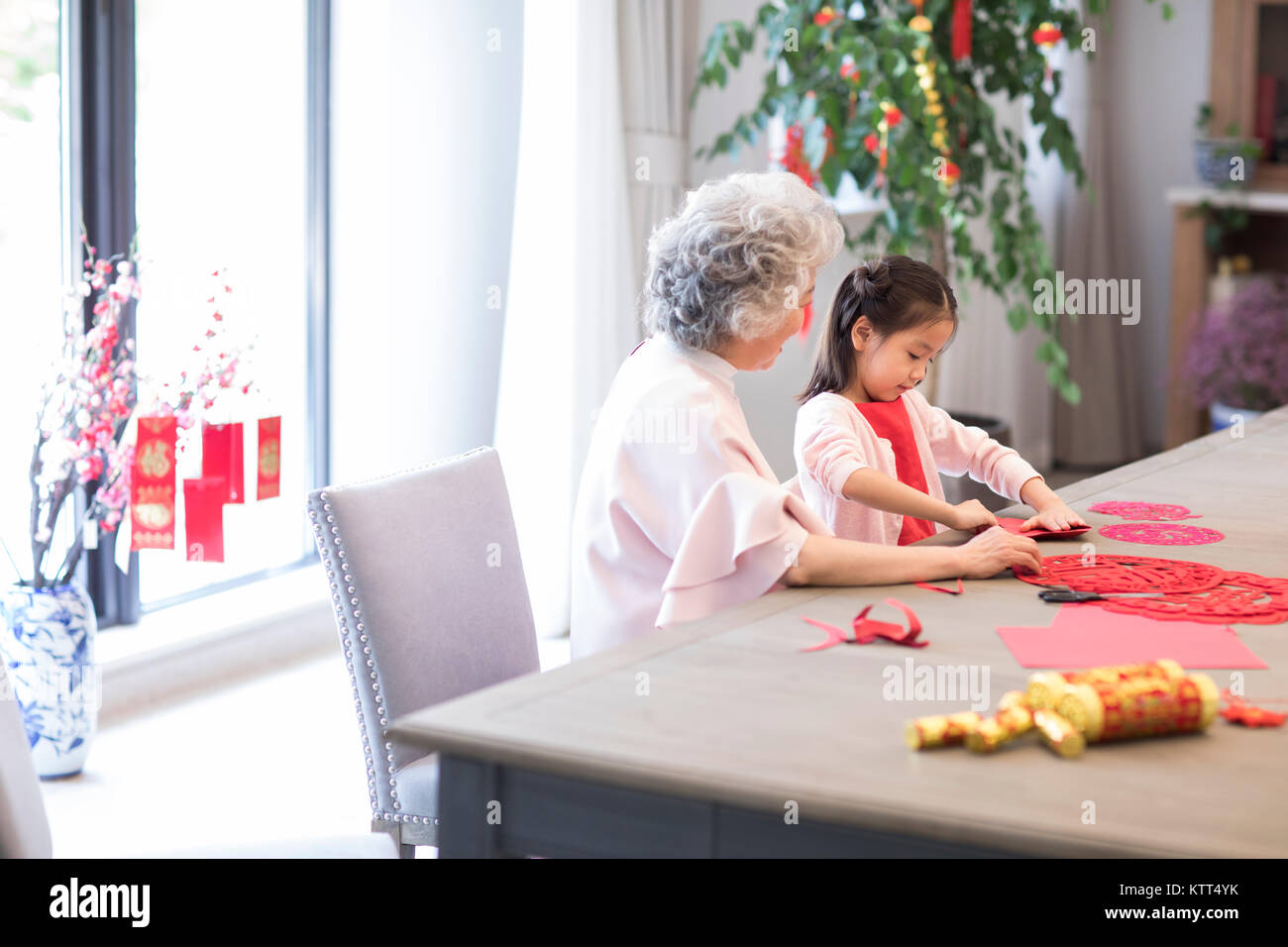 Granddaughter and grandmother with Chinese New Year paper-cut Stock ...