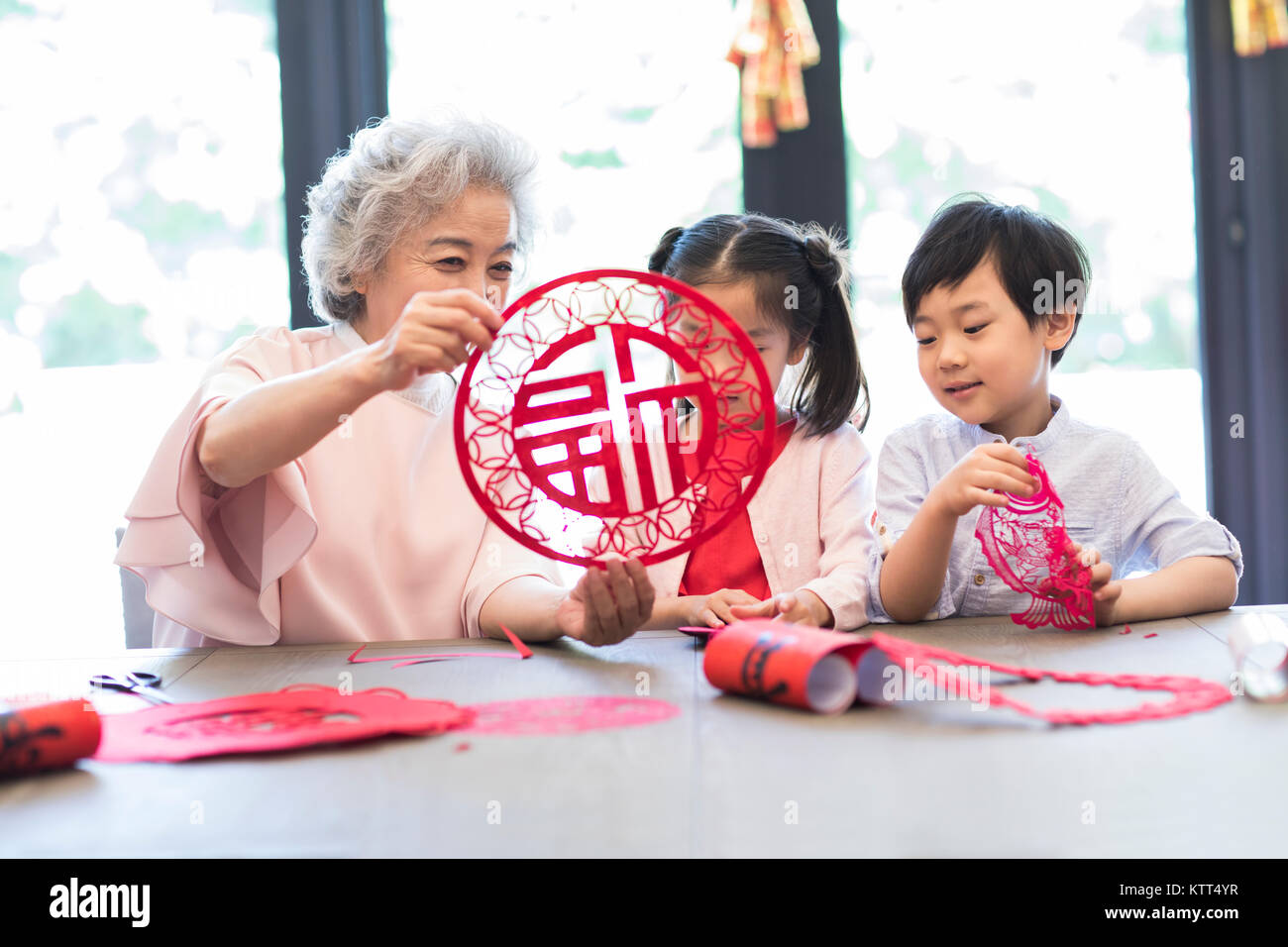 Grandchildren and grandmother with Chinese New Year paper-cut Stock ...