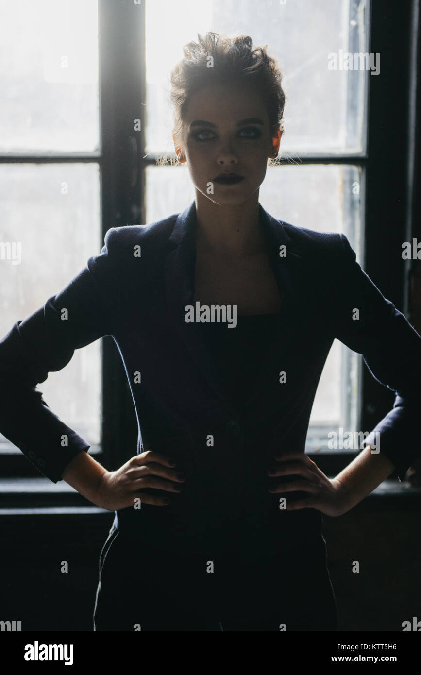 Portrait of a woman standing by a window Stock Photo - Alamy