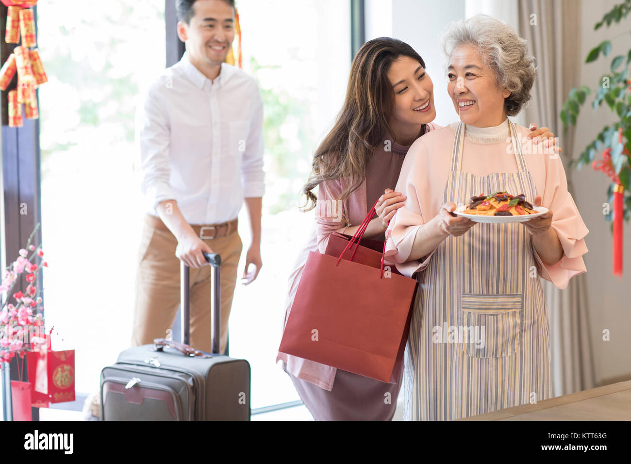 Young couple visiting their mother during Chinese new year Stock Photo ...