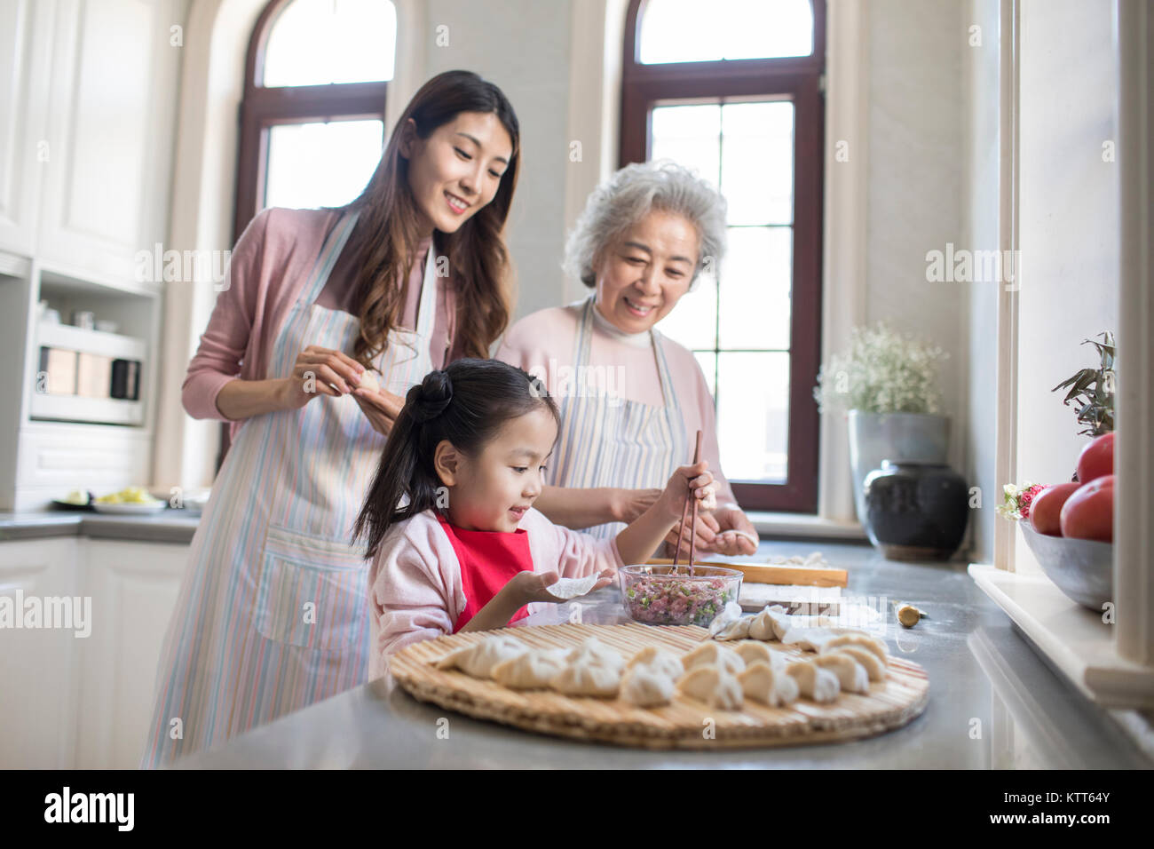 Cheerful family making dumplings in kitchen Stock Photo - Alamy