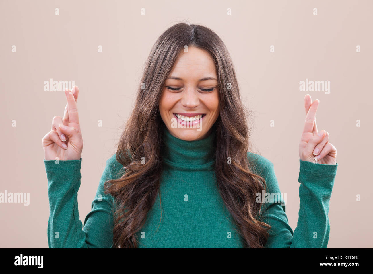Portrait of happy woman with fingers crossed Stock Photo - Alamy