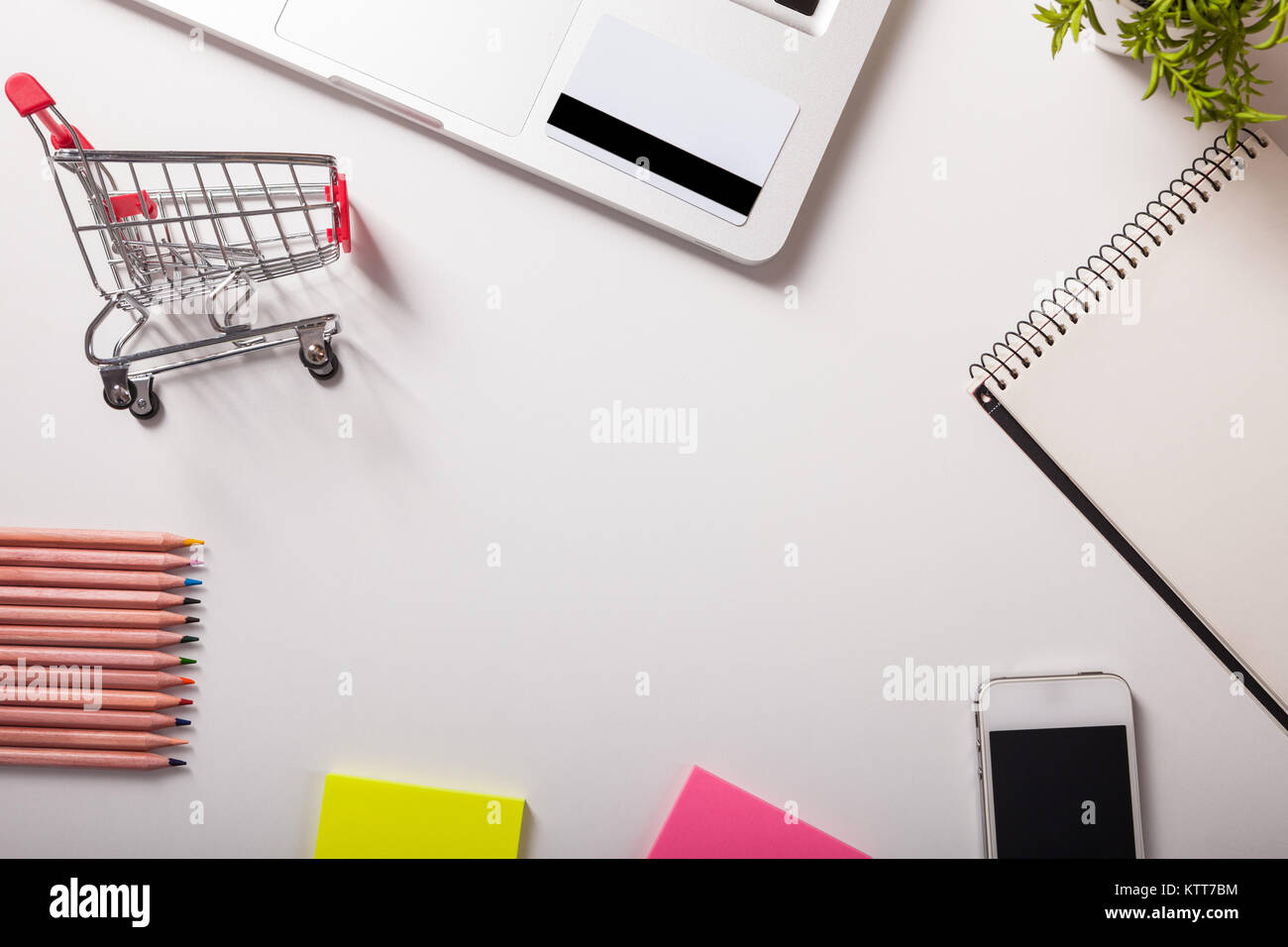 Online shopping. Bank card nearby a laptop and mini shopping cart on ...