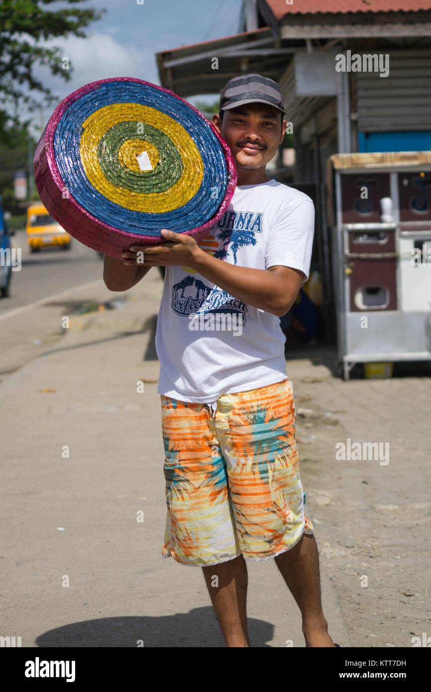 A man holding a large circle of explosive fire crackers, preparing for ...