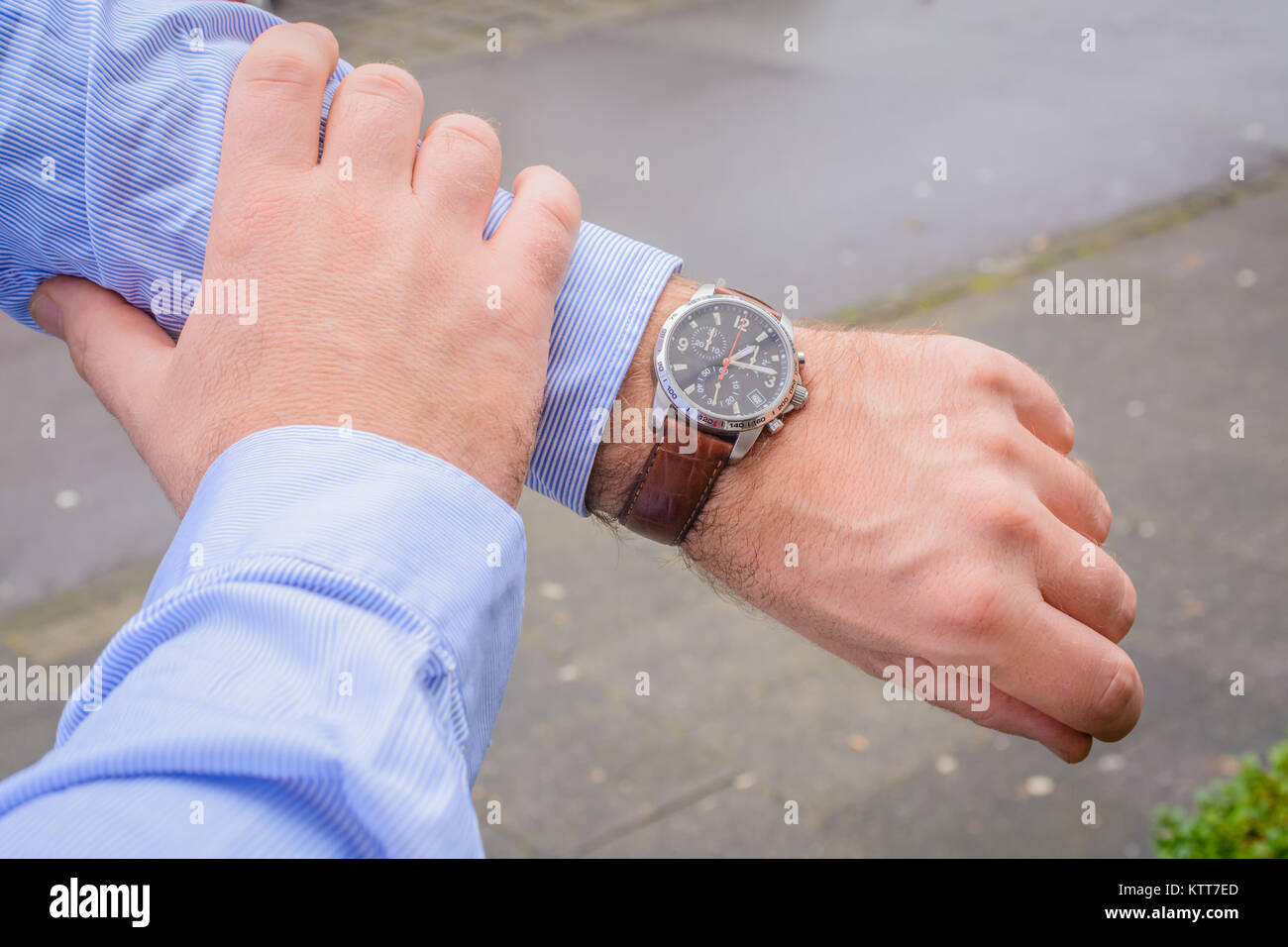 Business men looking at watch Stock Photo - Alamy