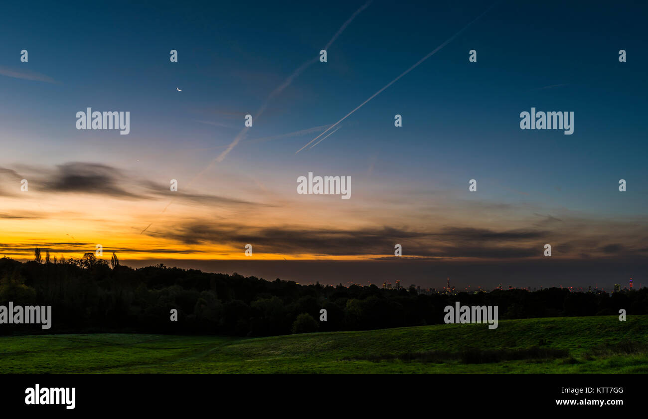 Early dawn and the moon over the London skyline from Hampstead Heath ...
