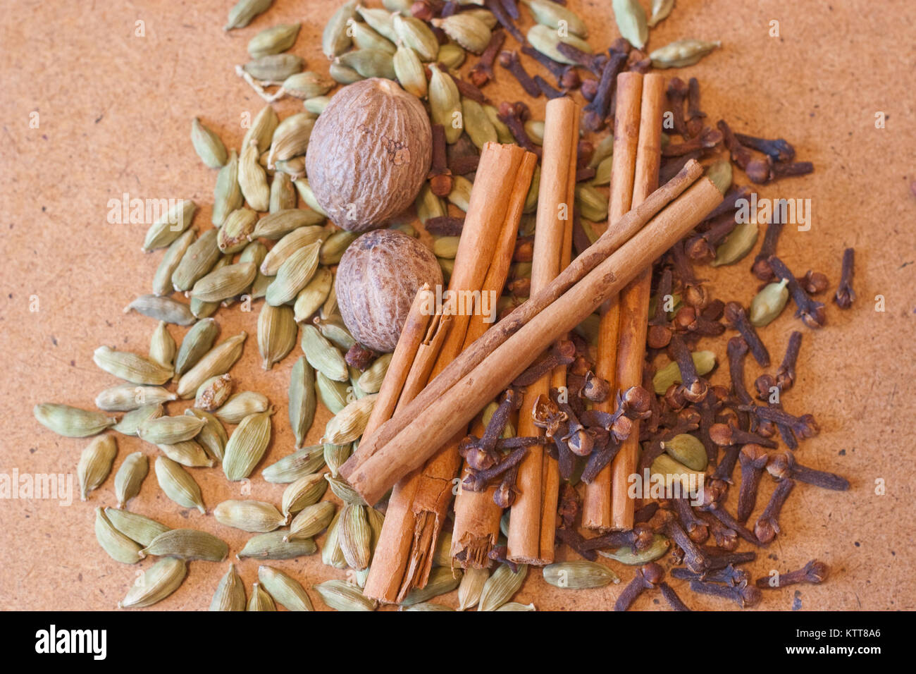 Cardamom pods, cinnamon sticks, whole nutmeg and cloves on plain ...