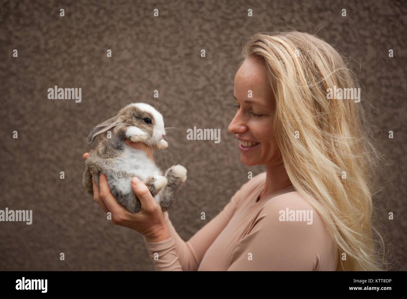Idealistic young blonde woman daydreaming with Christmas bunny rabbit ...