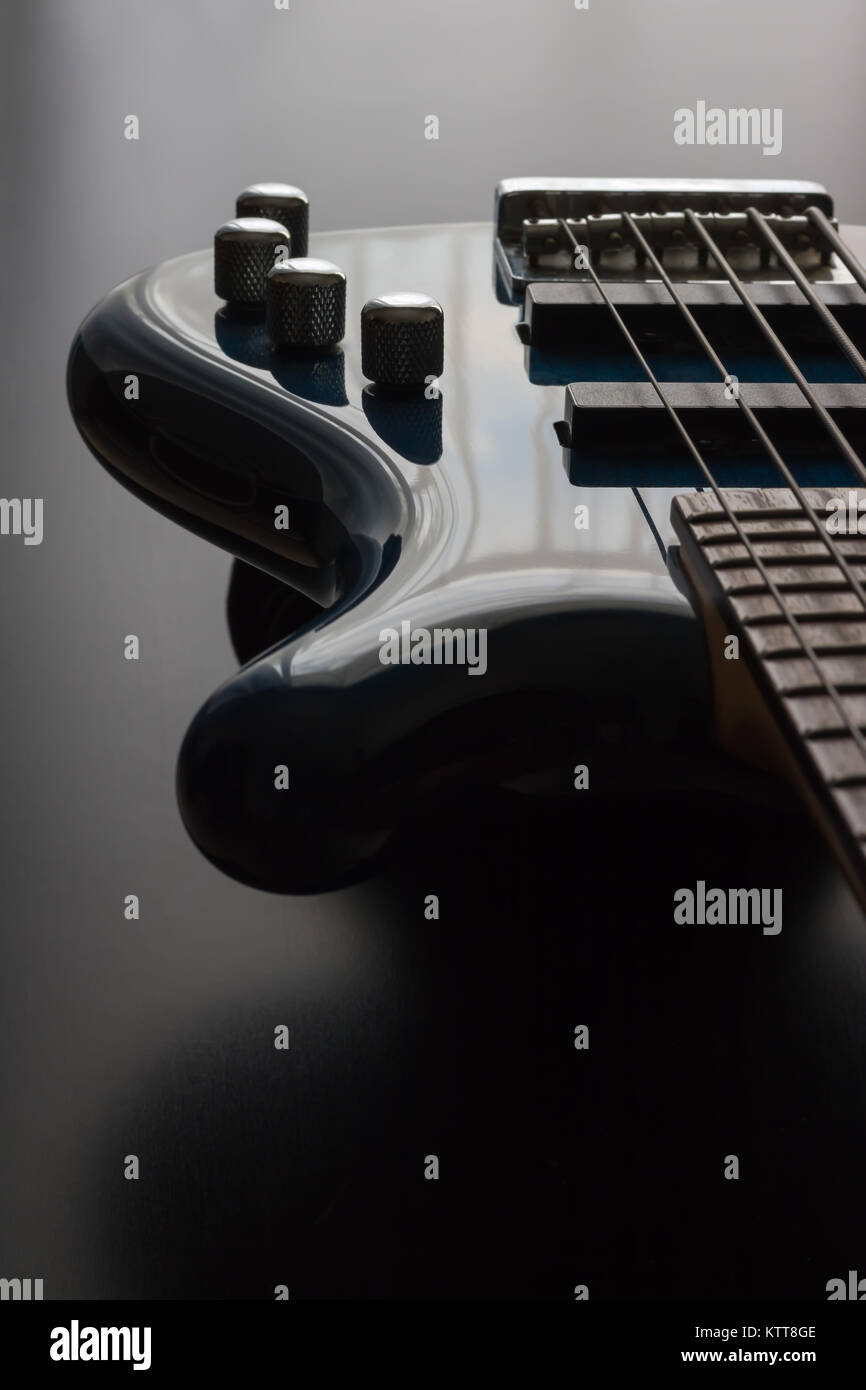 A blue five string bass guitar is strategically positioned in the frame ...