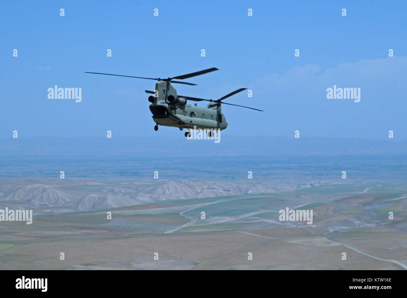 An aerial view of a Chinook helicopter flying over the mountains ...
