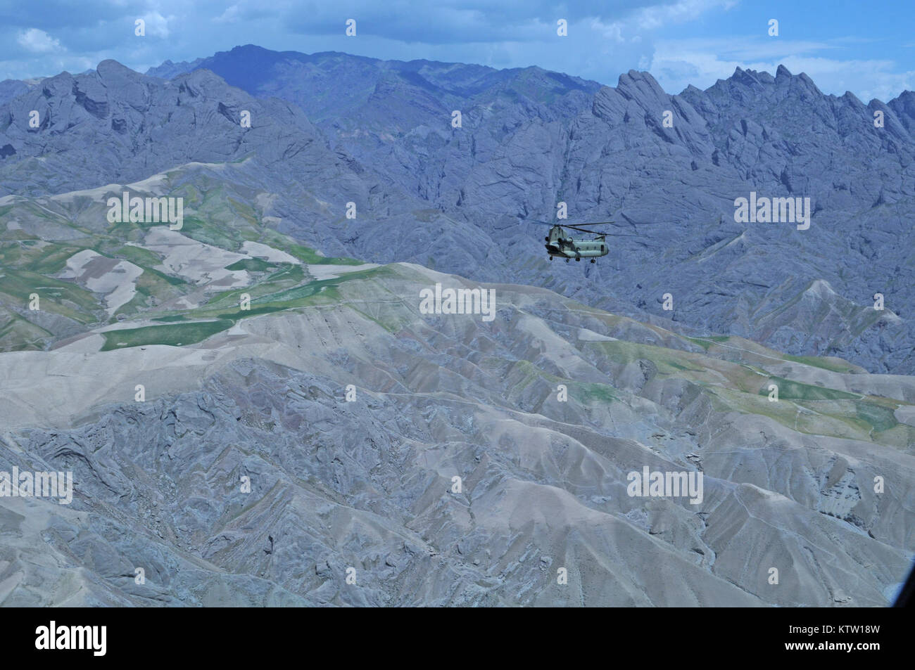 An aerial view of a Chinook helicopter flying over the mountains ...