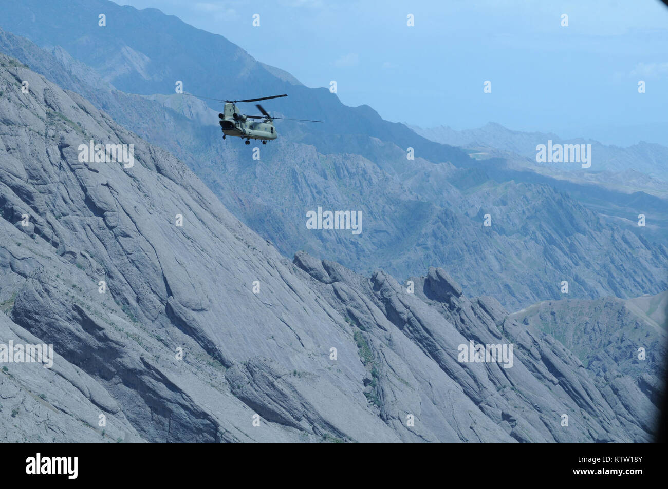 An aerial view of a Chinook helicopter flying over the mountains ...