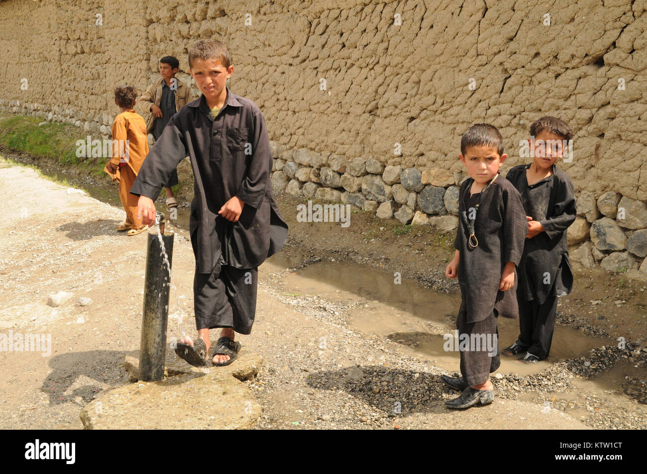 An Afghan child washes his feet in the village water source in Khwahan ...