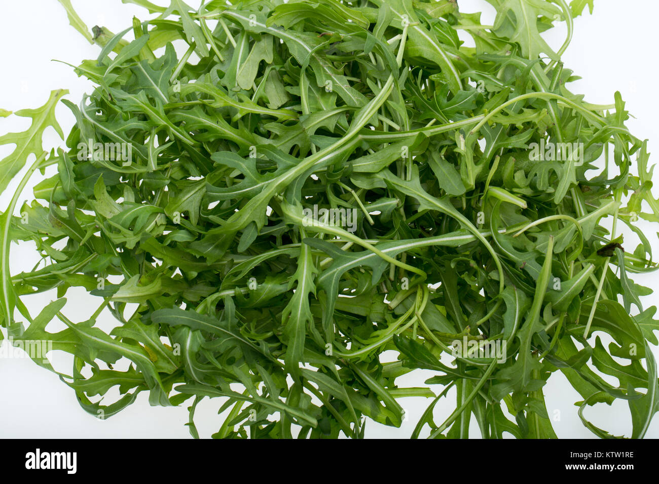 Heap of ruccola leaves isolated on white background Stock Photo - Alamy