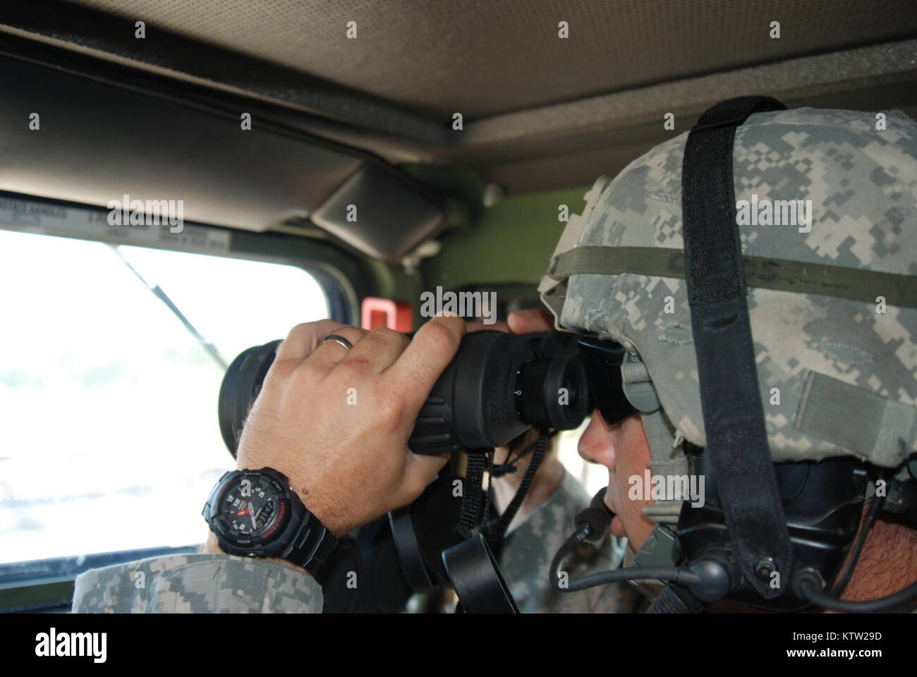 Tank Commander, Sgt. Brian Davis observes rounds going down-range while ...