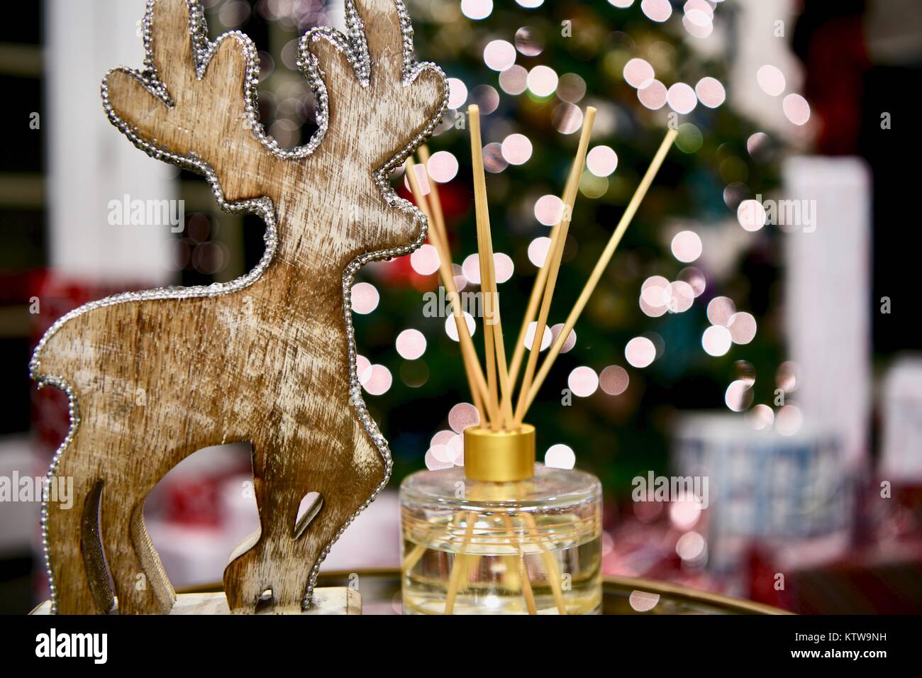 Wooden reindeer Christmas decor next to a reed diffuser with Christmas ...