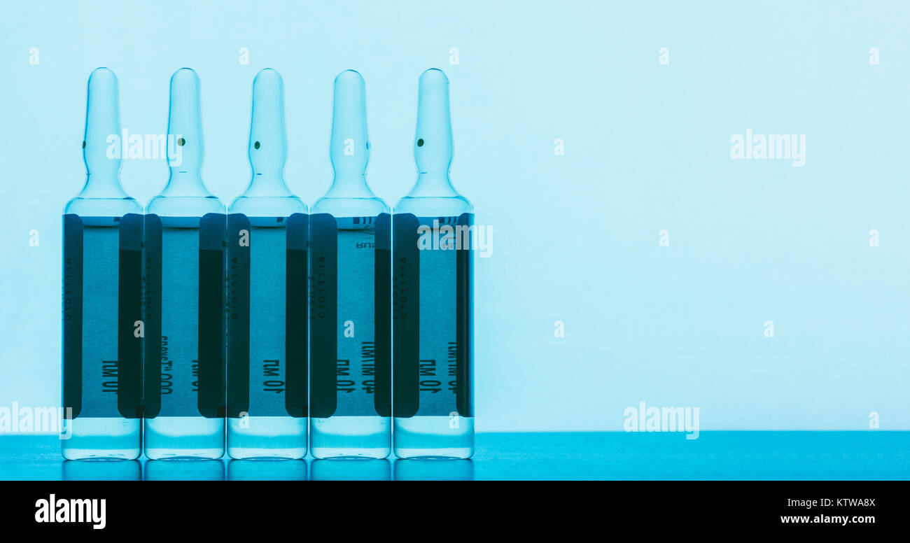 the ampoules with solution for injections on a blue background with ...