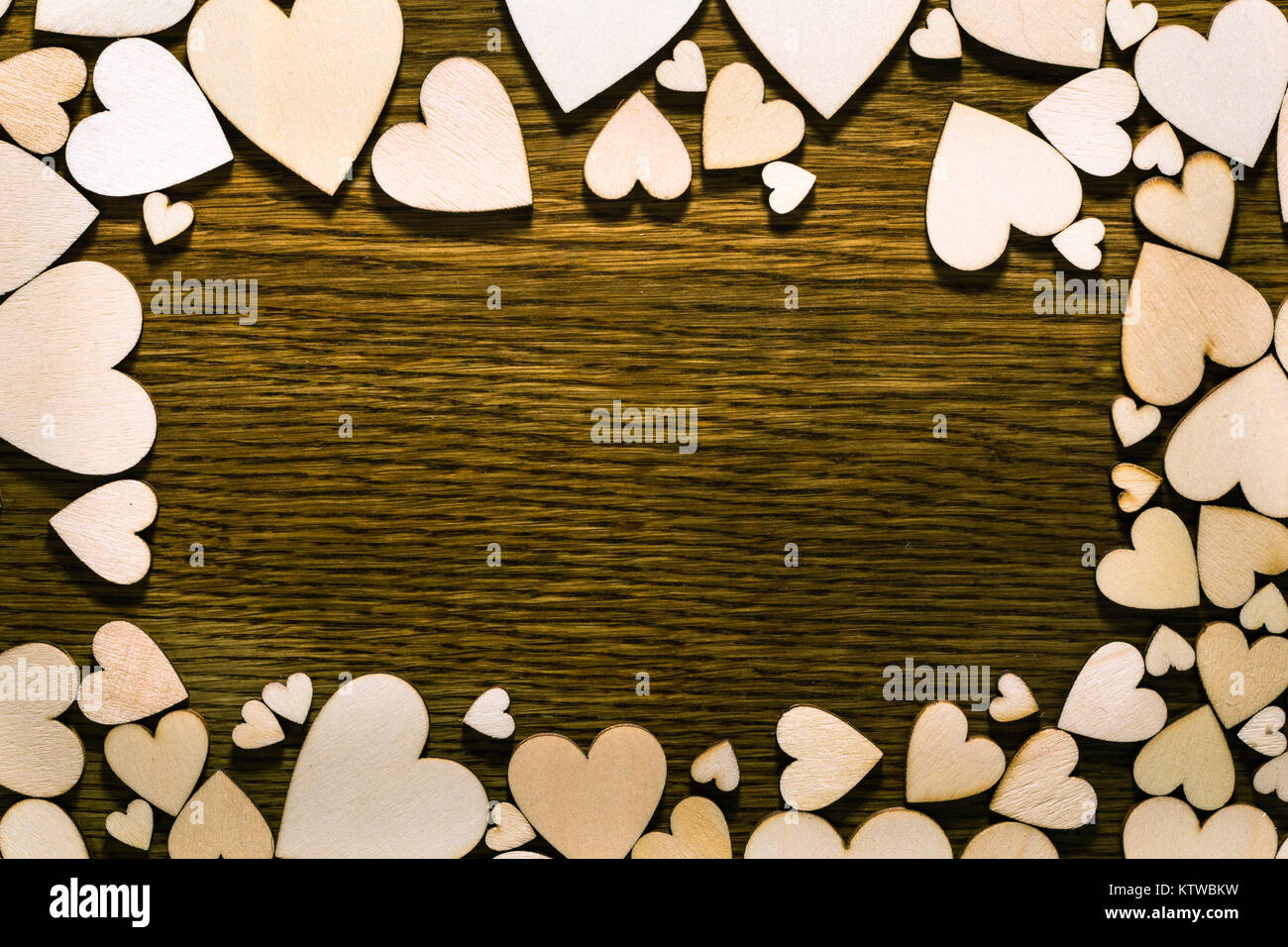 Love frame with light hearts around and dark wooden background in the ...