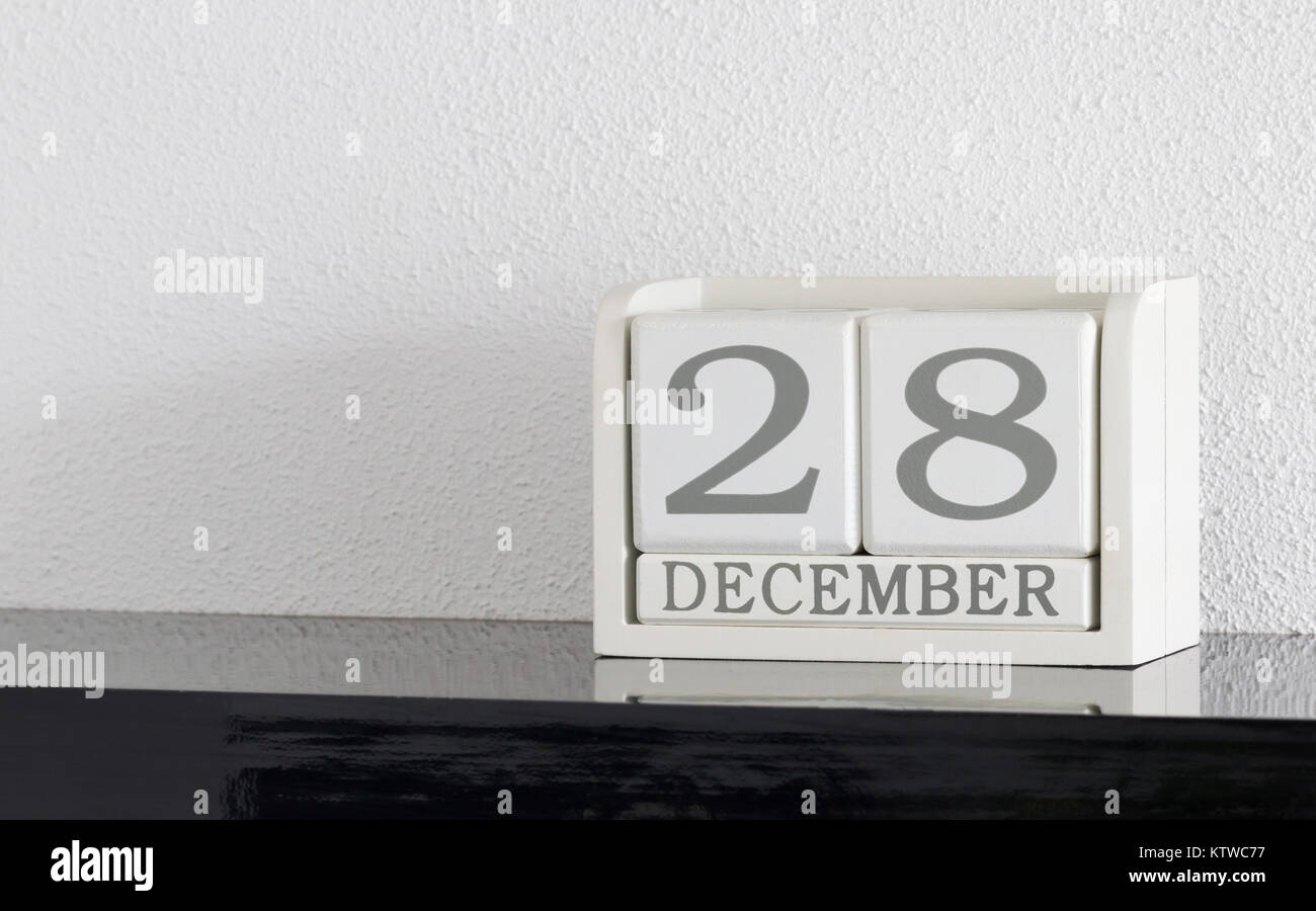 White block calendar present date 28 and month December on white wall ...