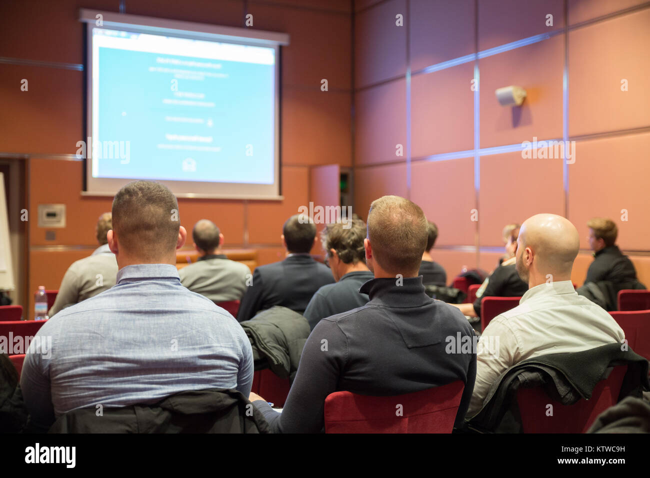 Audience in conference hall listening to presentation on business ...