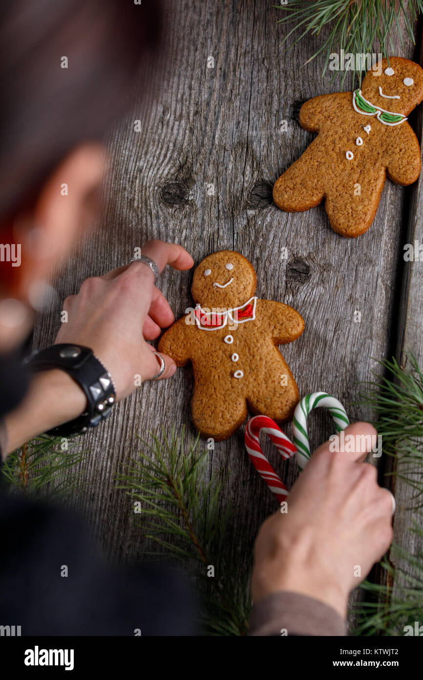 A girl is decorating a table for Christmas. Gingerbread men. Ginger ...