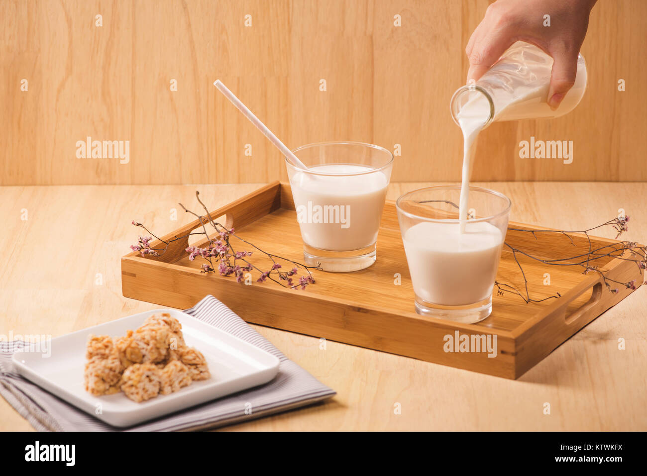 milk pour from bottle, almond candies on wooden background Stock Photo ...