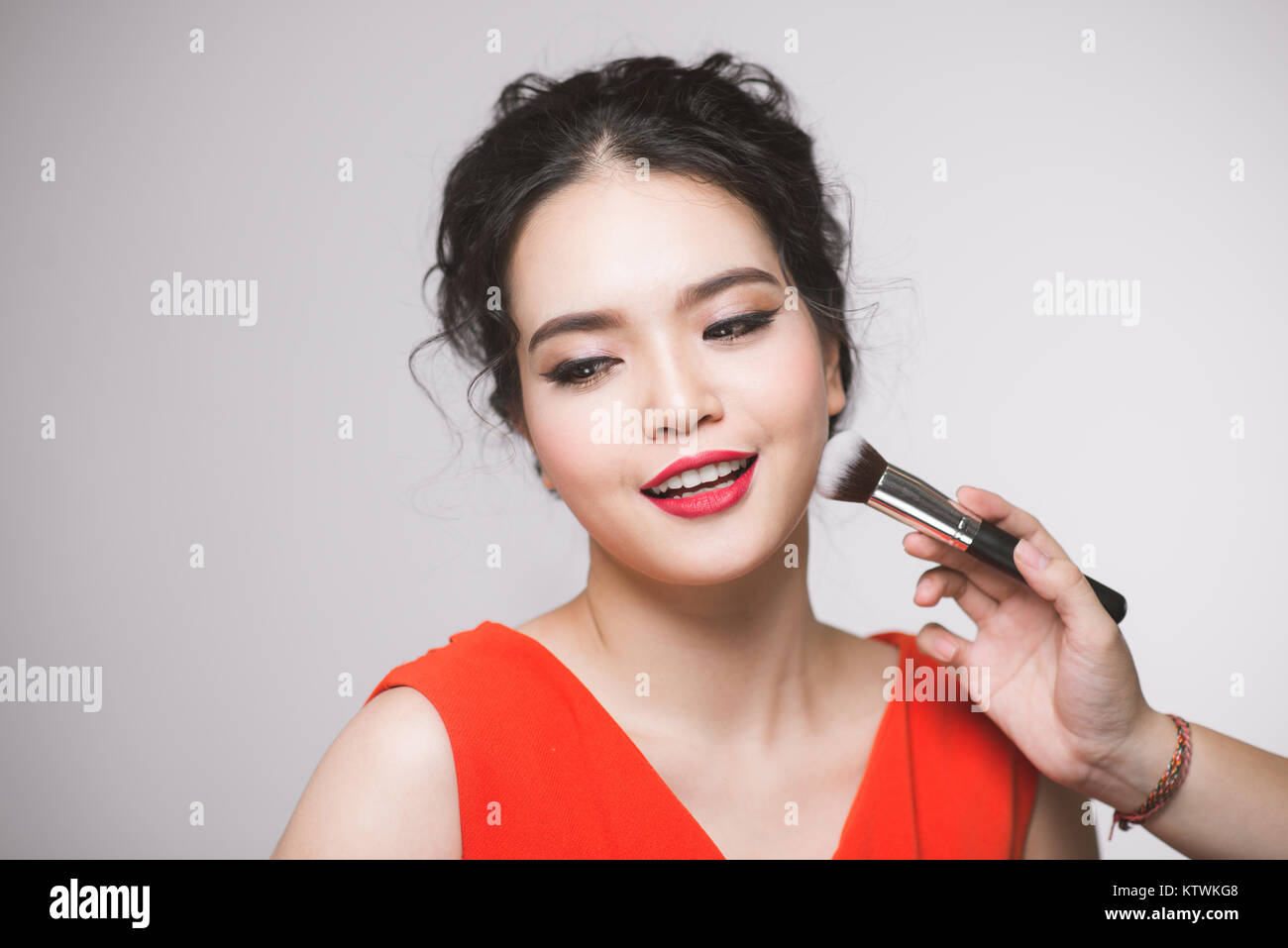 Portrait of attractive asian young adult woman applying blusher Stock Photo - Alamy