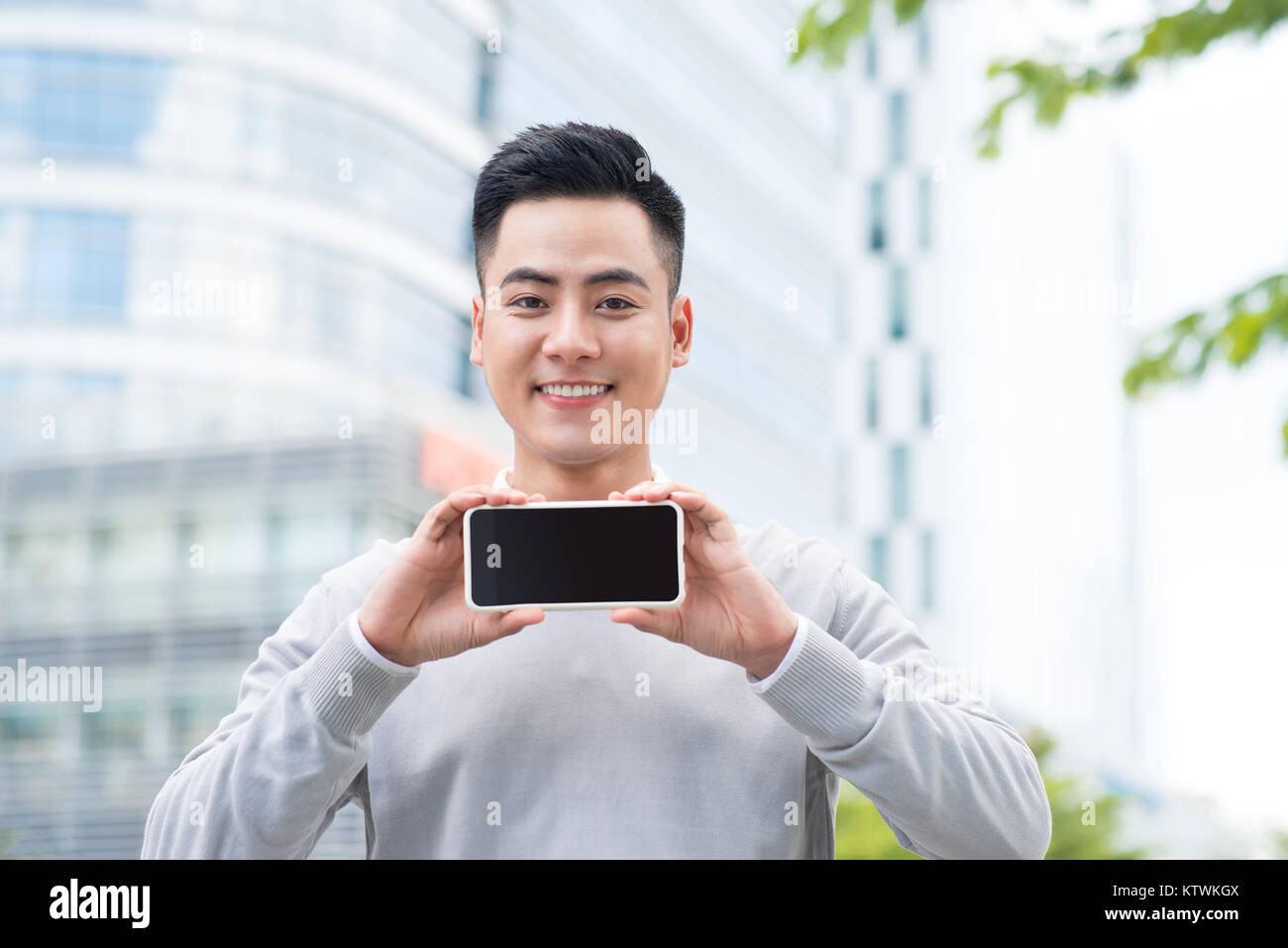 Business man holding and showing screen of smart phone Stock Photo - Alamy