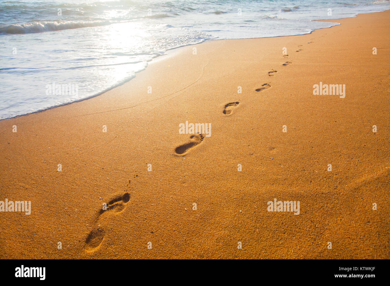 beach, wave and footprints at sunset time Stock Photo - Alamy