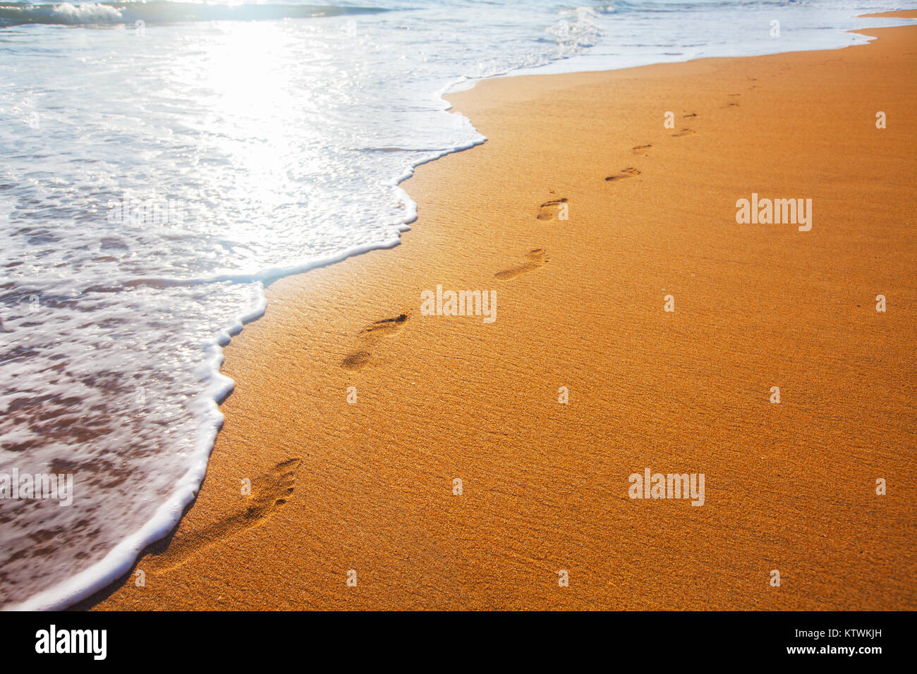beach, wave and footprints at sunset time Stock Photo - Alamy