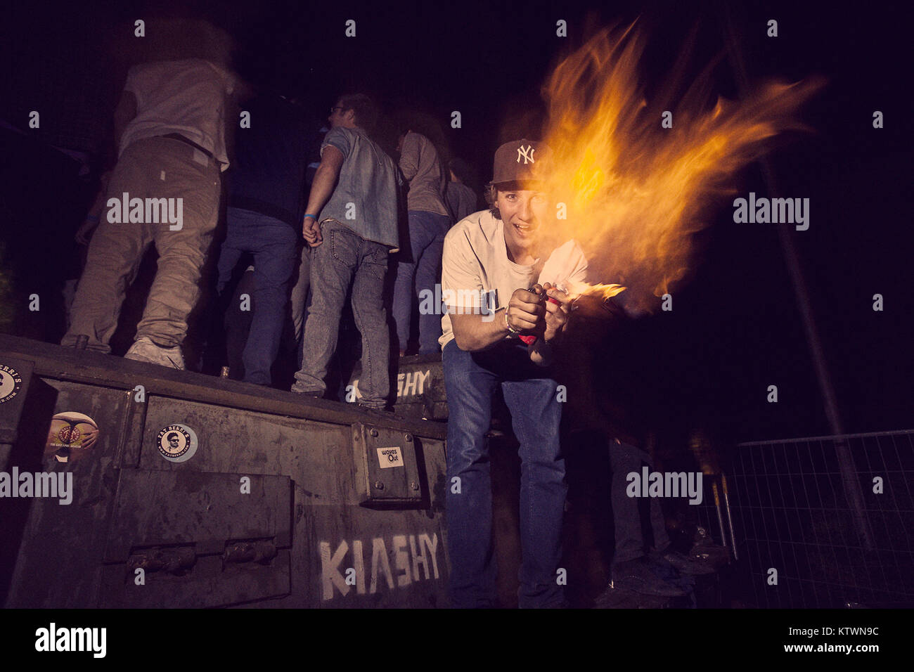 A party guy is setting fire to a can and creating a wild atmosphere at ...
